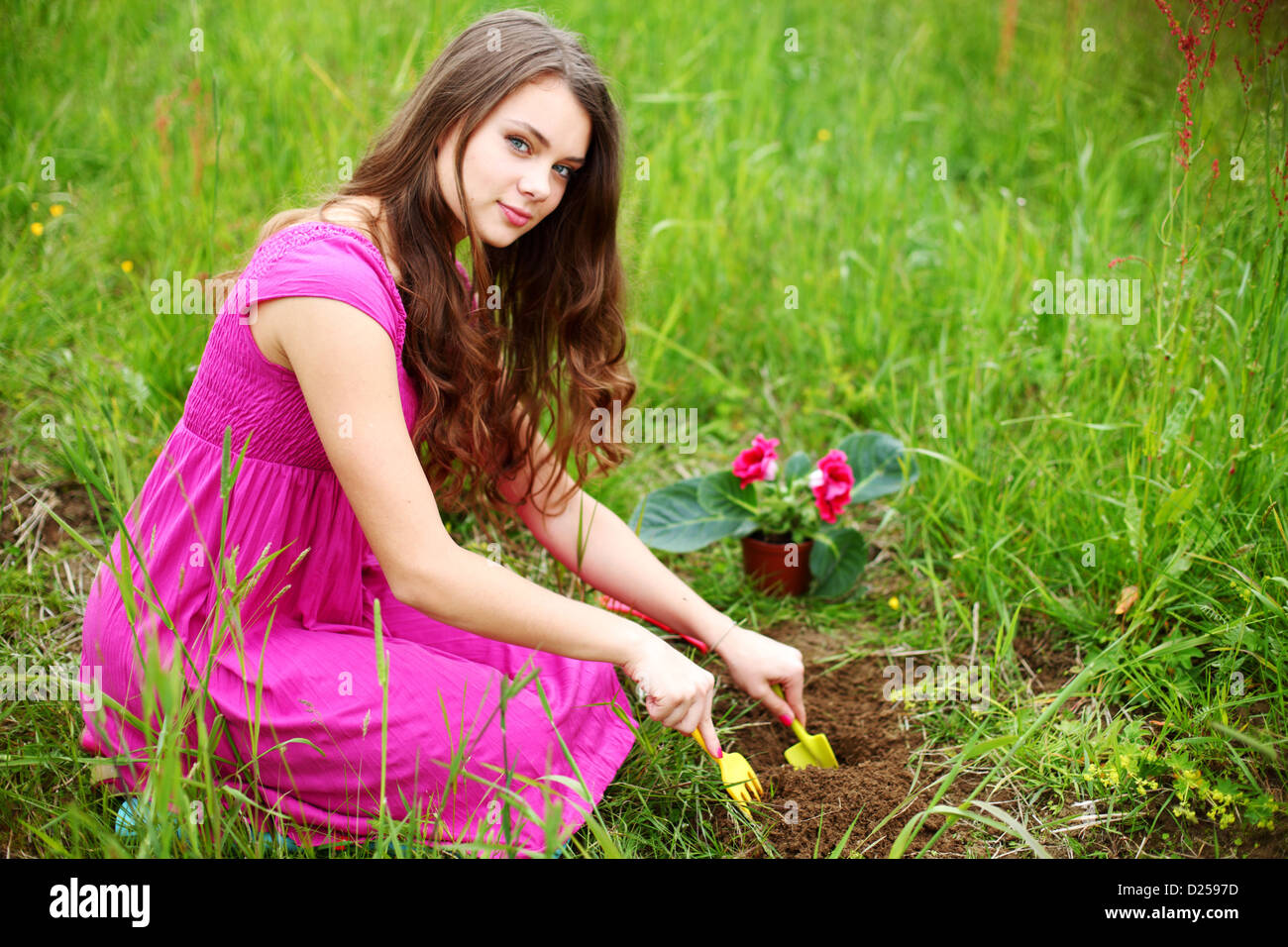 girl grow flower on green field Stock Photo - Alamy
