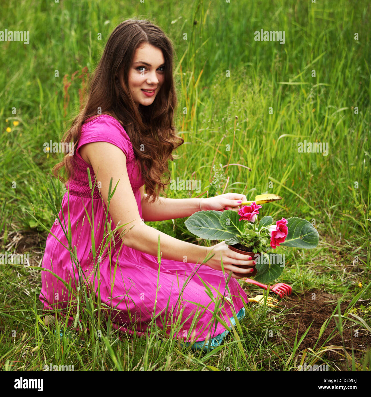 girl grow flower on green field Stock Photo - Alamy