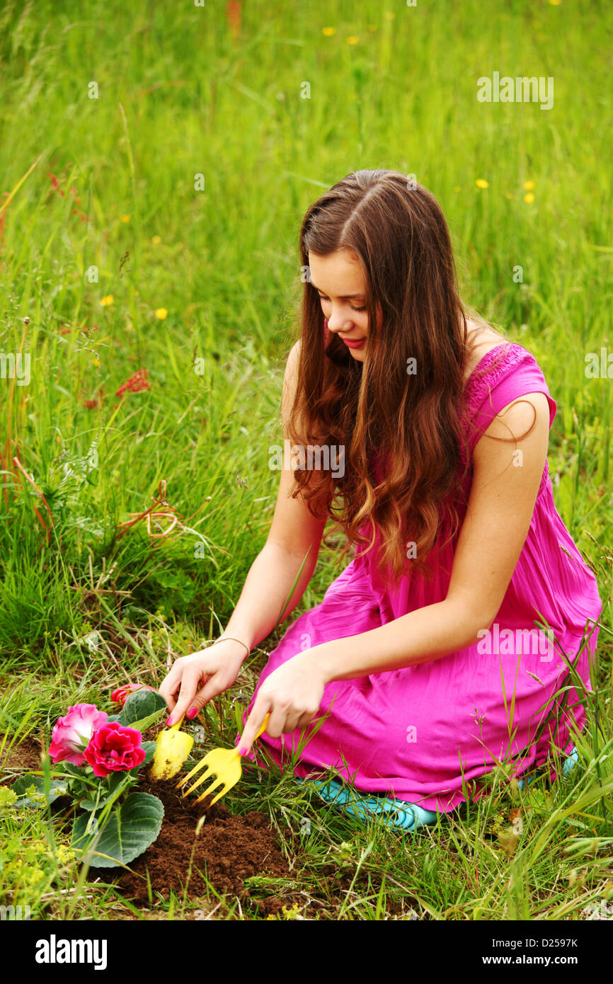 girl grow flower on green field Stock Photo - Alamy