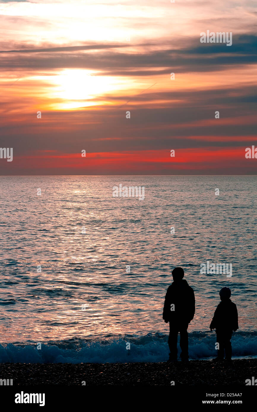 Two kids silhouette at the sunset Stock Photo - Alamy