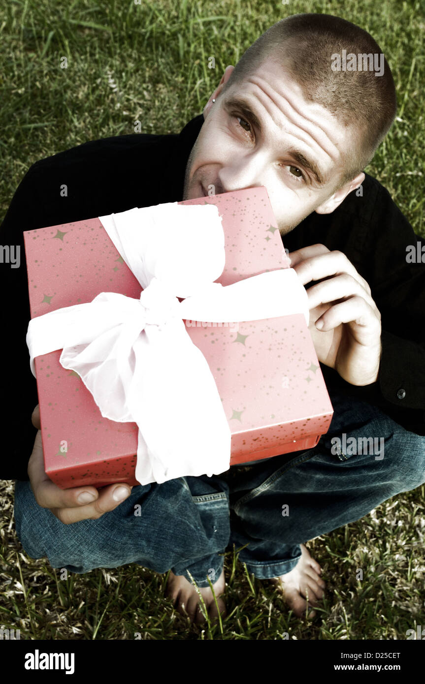 Caucasian man with a red present Stock Photo - Alamy