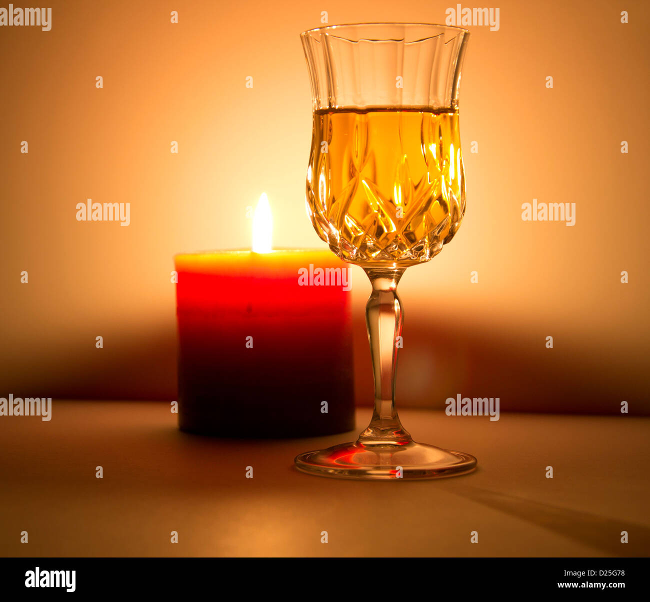 A candle gives light to a fine liquor Stock Photo - Alamy
