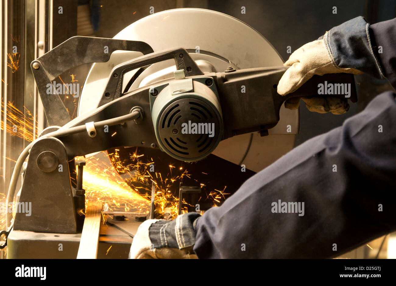 A worker operating a grinder Stock Photo - Alamy