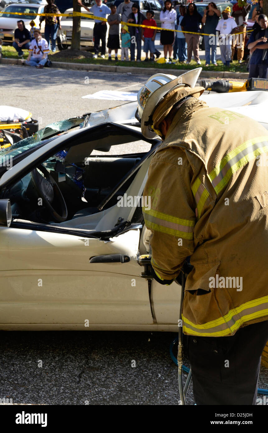 Firefighters work on freeing a person trapped in a wrecked car in ...