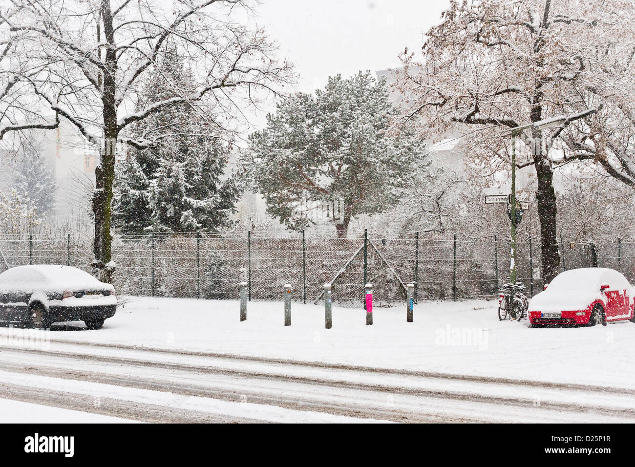 Snow-covered cars parked on a quiet street corner after a heavy ...