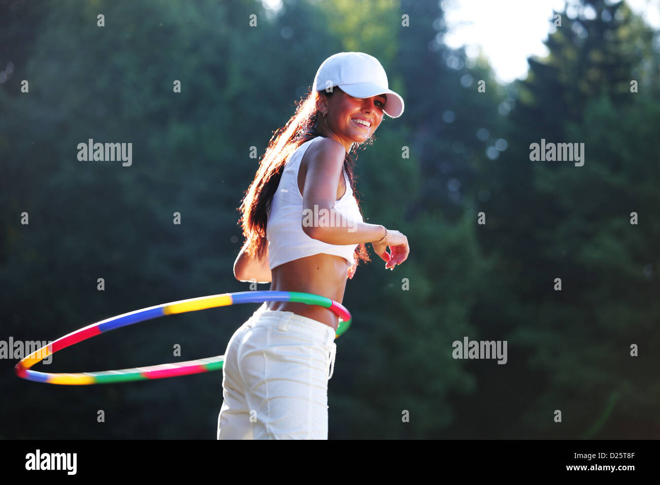 woman rotates hula hoop on nature background Stock Photo - Alamy