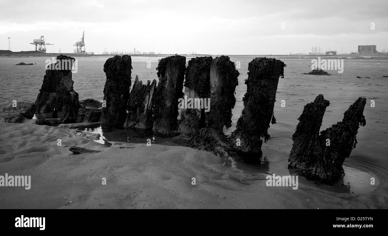 The remains of an old ship wreck are visible at low tide on the beach ...
