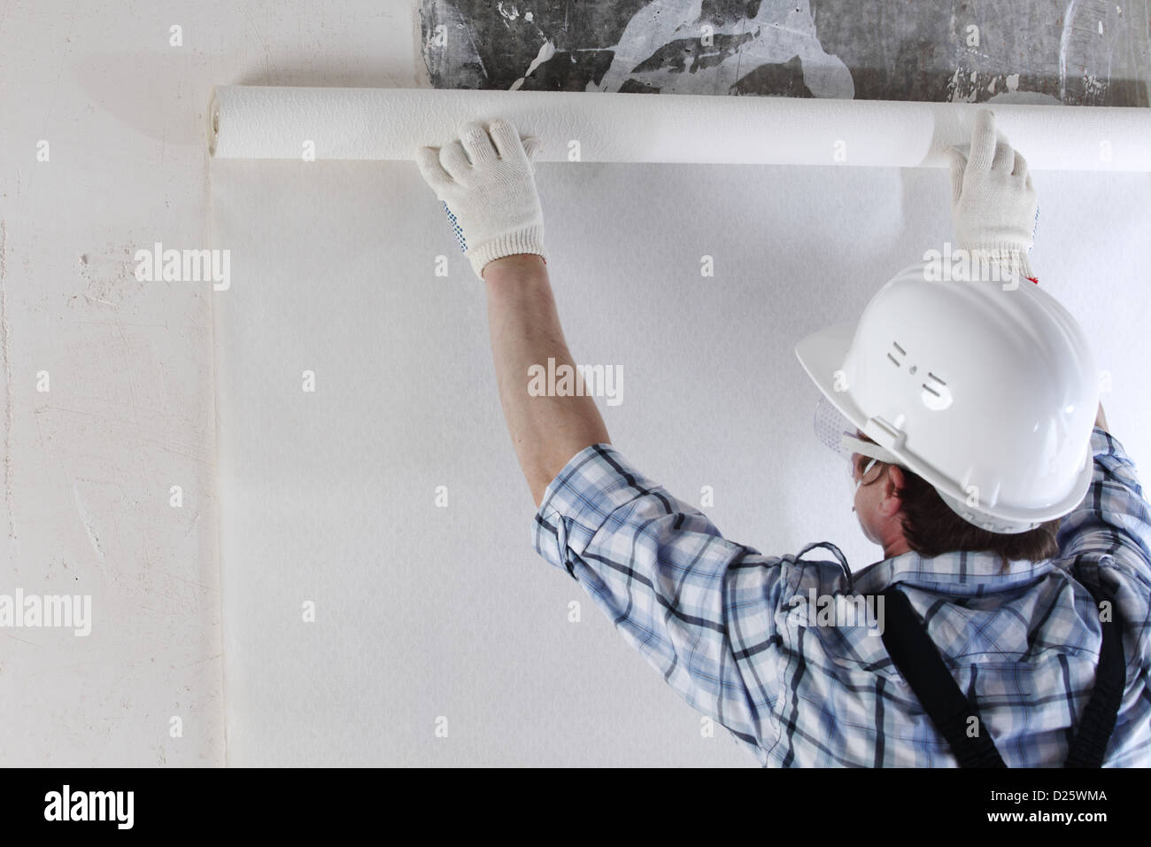 worker attaching wallpaper to wall Stock Photo - Alamy