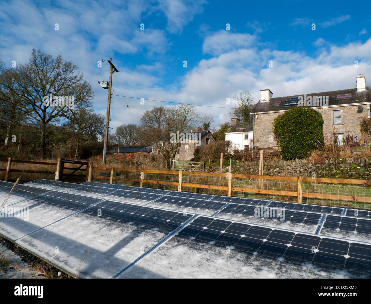 Snow frost on free standing solar panels panel and stone house home ...