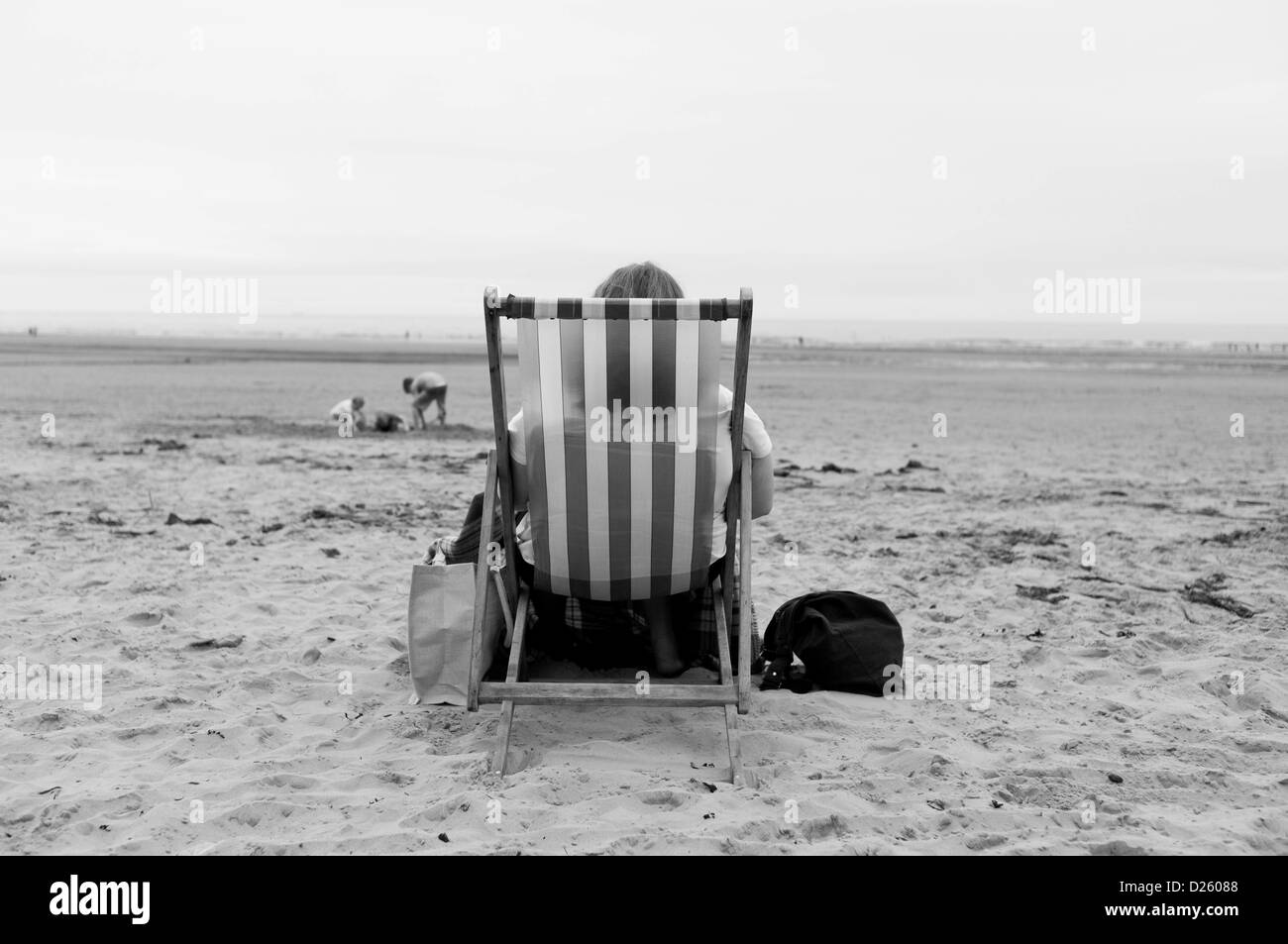 A woman relaxes on a deck chair on Saltburn beach in Cleveland, England ...