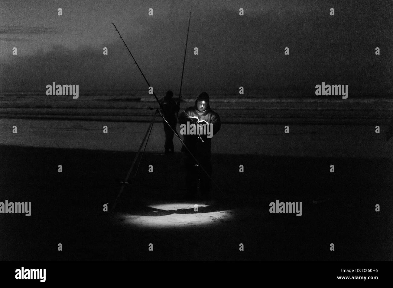 An angler prepares his line during a night time beach fishing ...