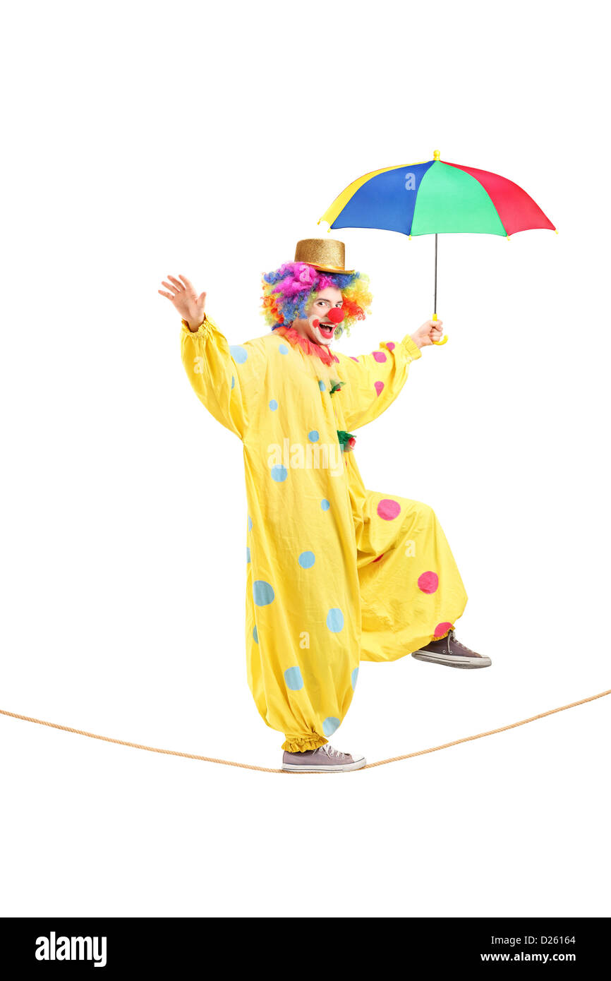 Full length portrait of a happy male clown with umbrella walking on a ...