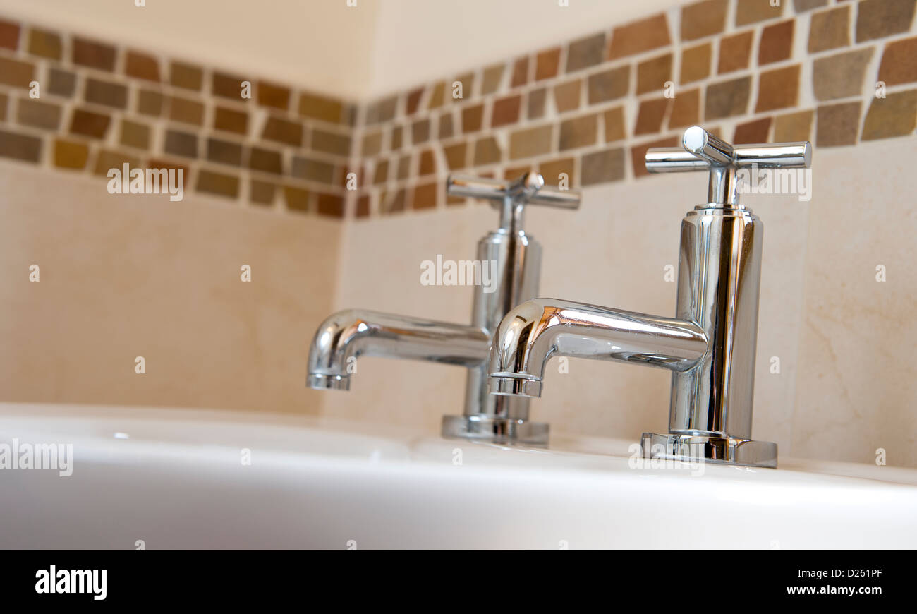 Close up of taps on a wash basin in a modern bathroom in a newly ...