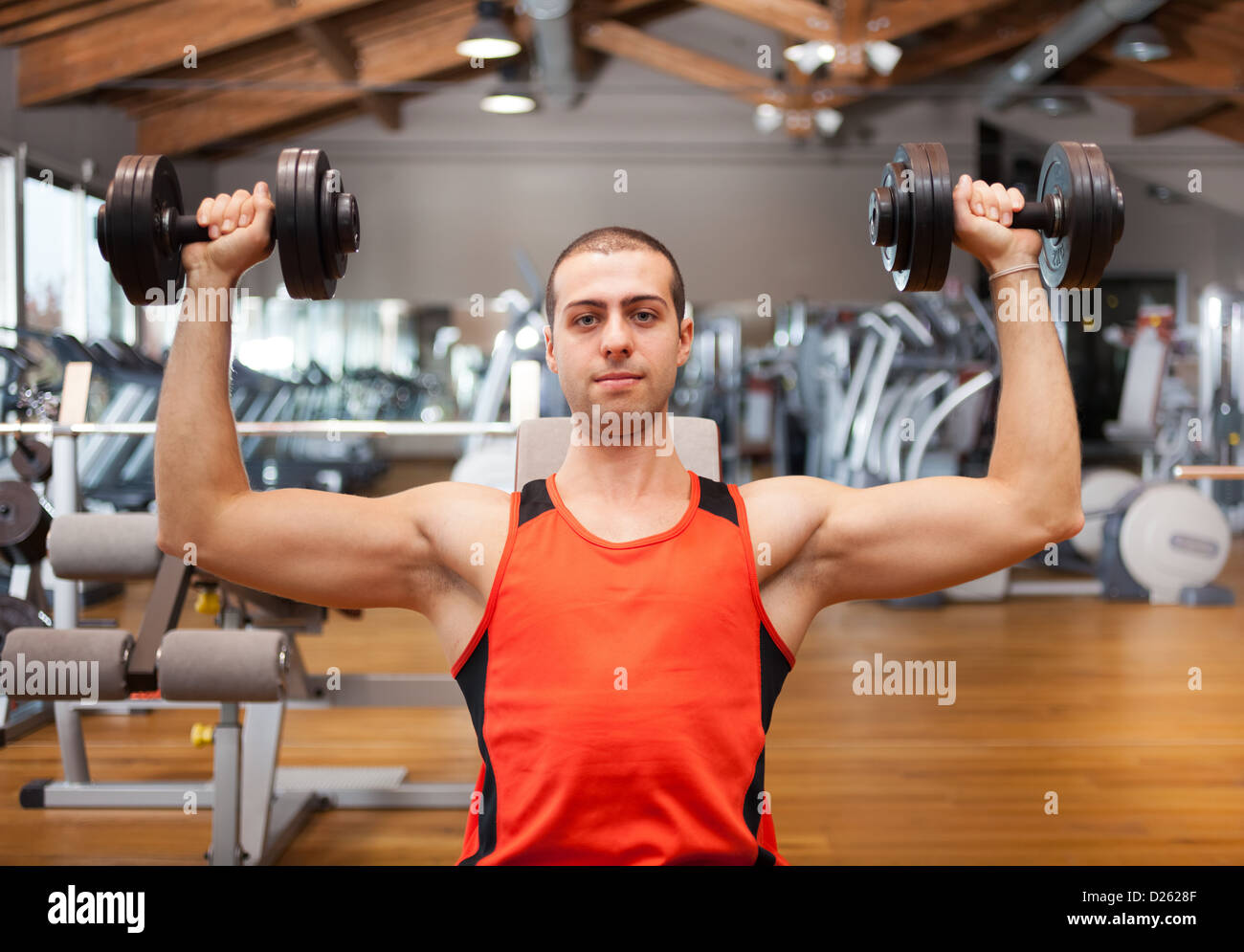 Man lifting a weight in a fitness club Stock Photo - Alamy