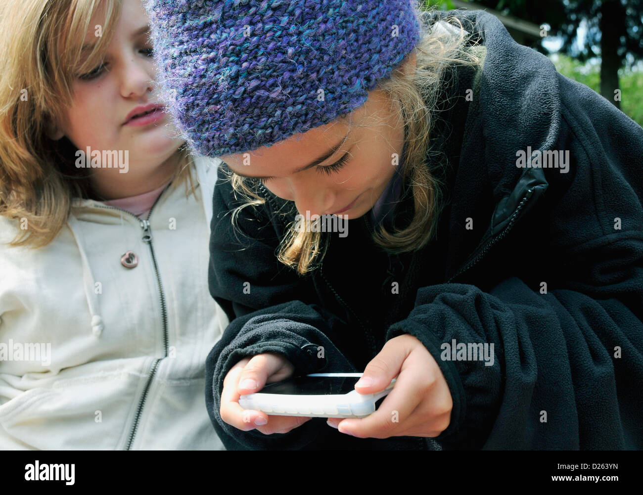 two girls playing on an iphone Stock Photo - Alamy