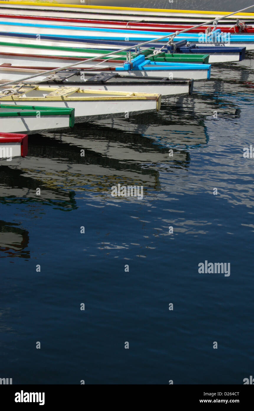Row of moored rowing boats reflection on water surface Stock Photo - Alamy