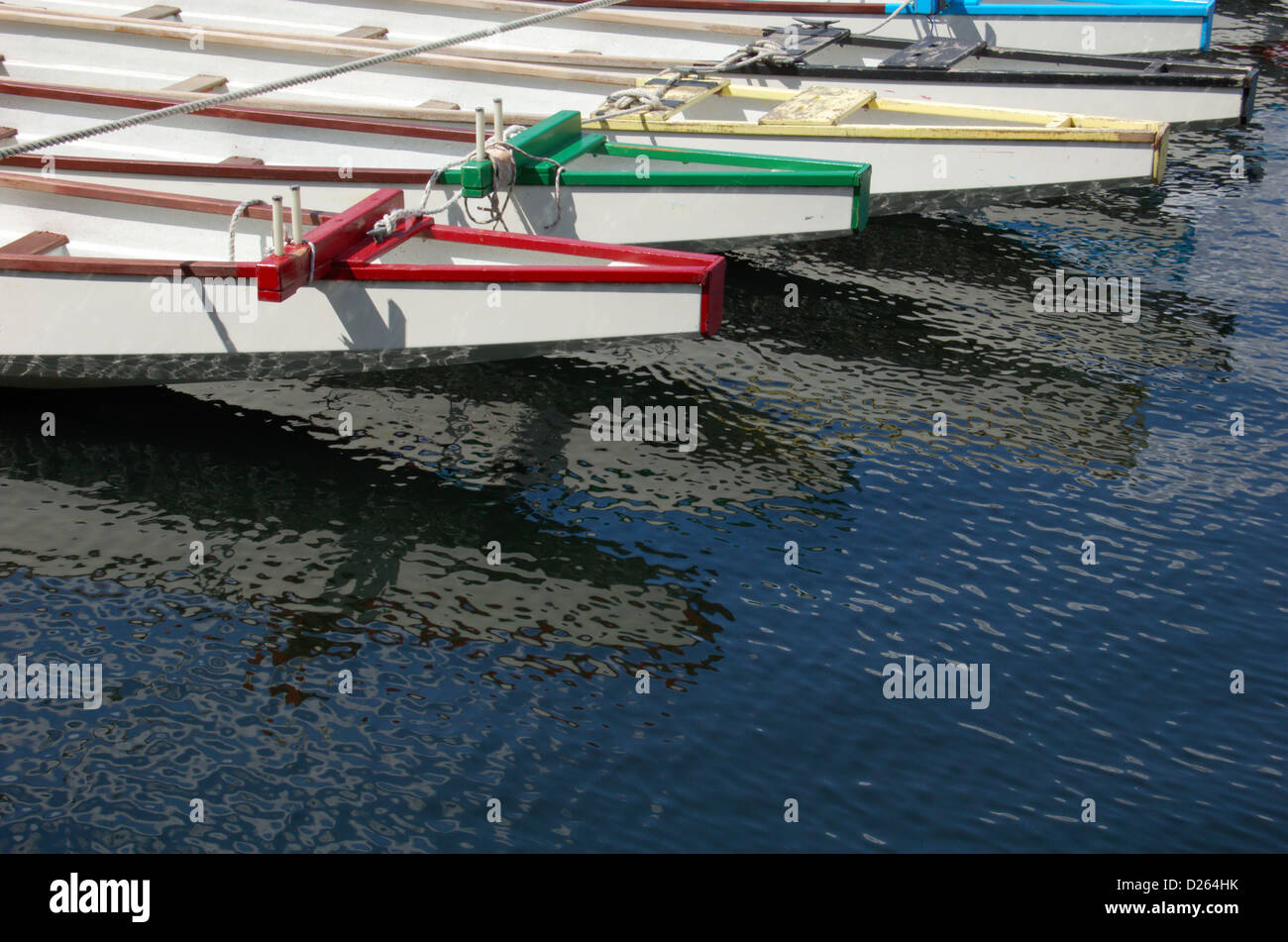 Row of moored rowing boats reflection on water surface Stock Photo - Alamy