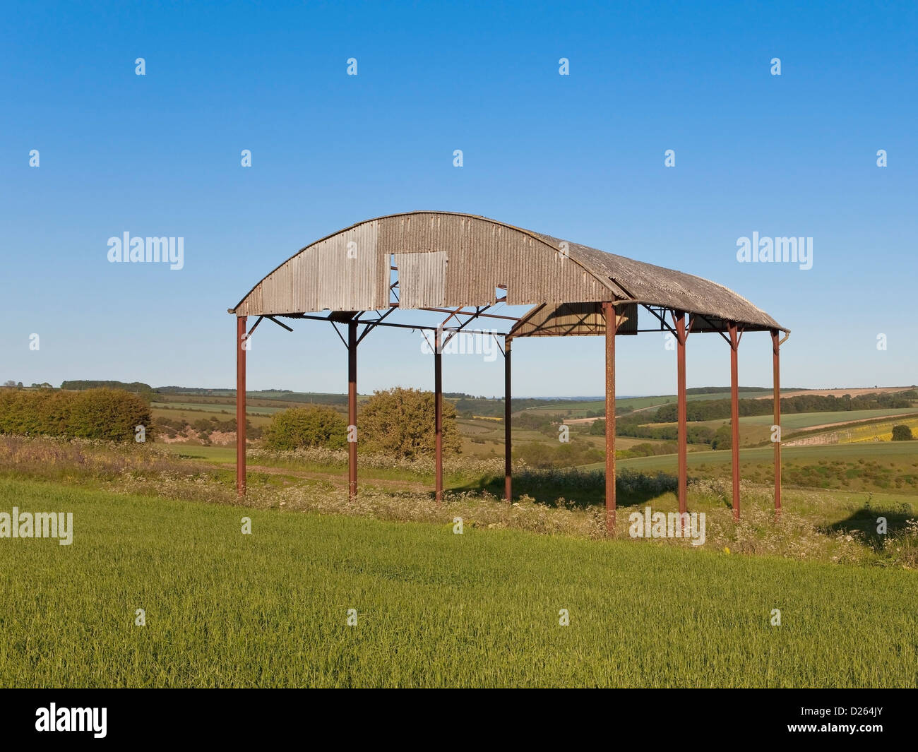 An old derelict barn on a hillside in an agricultural landscape under a ...