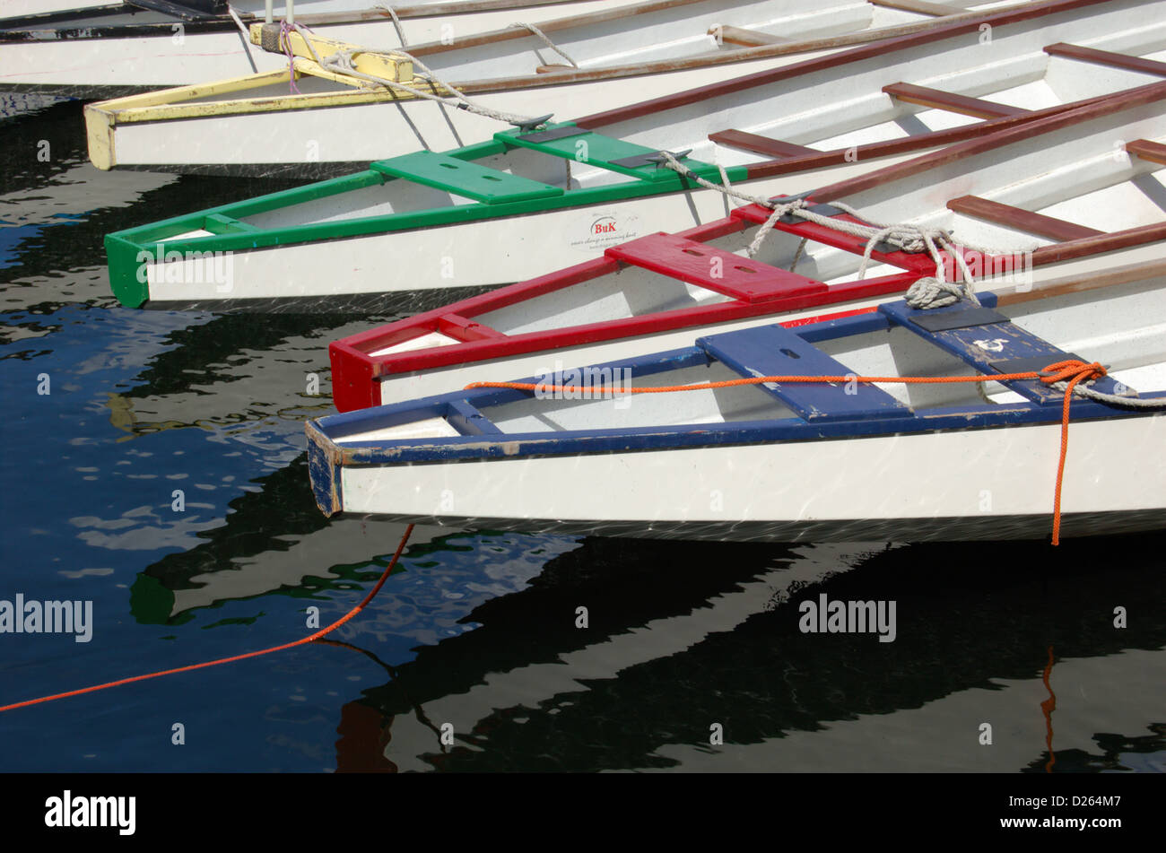 Row of moored rowing boats relfecting on water surface Stock Photo - Alamy
