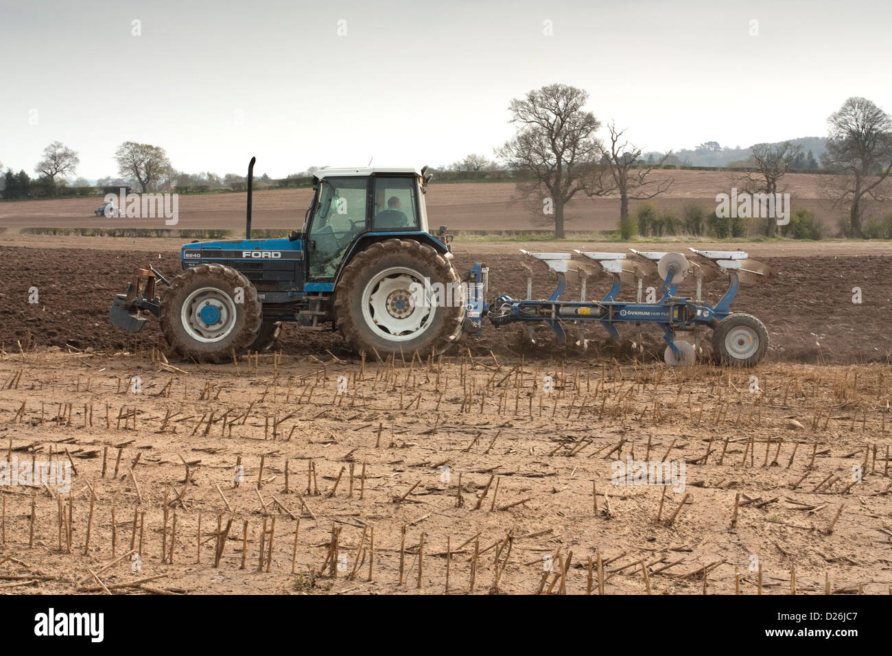 Tractor ploughing field in rural countryside Stock Photo - Alamy
