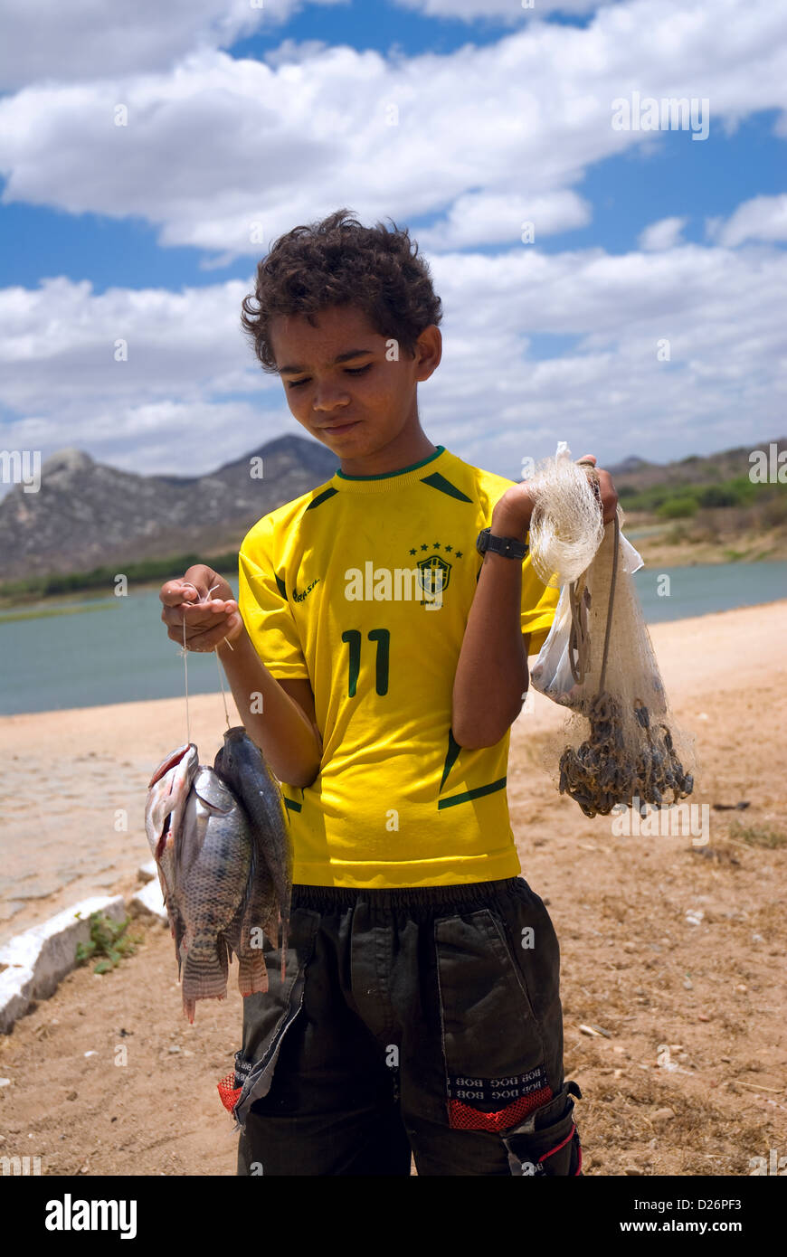 A young boy holding fishes Stock Photo - Alamy