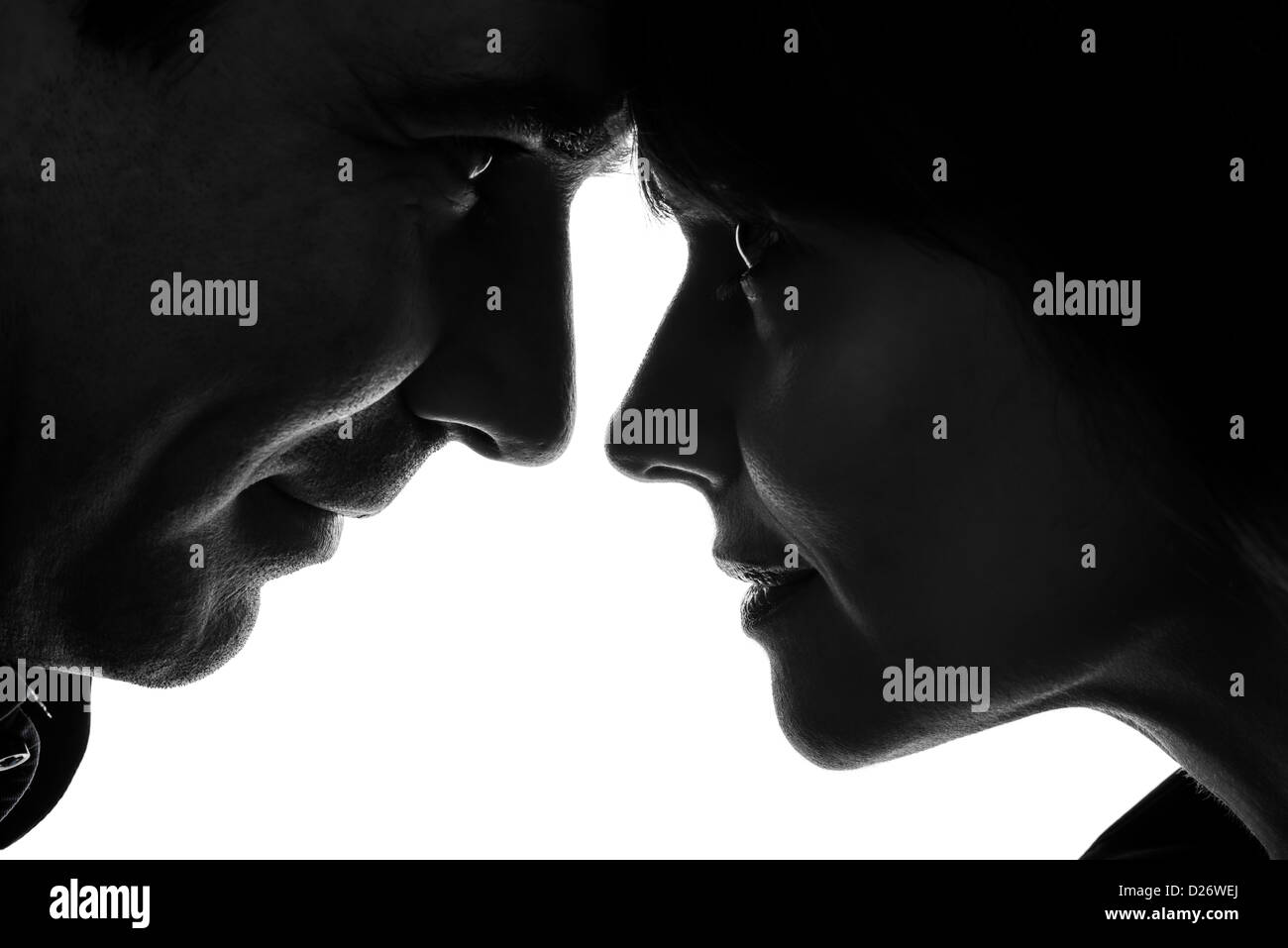 one couple woman man face to face in silhouette studio isolated on ...