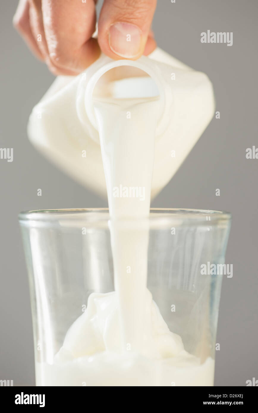 Hand pouring milk Stock Photo - Alamy