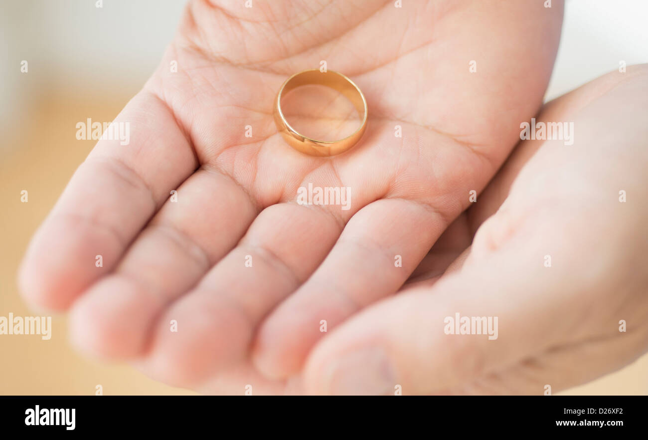 Hand holding wedding ring Stock Photo - Alamy