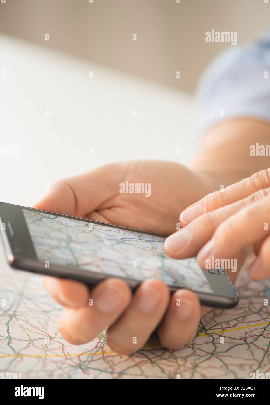 Close-up of hand using smartphone over map Stock Photo - Alamy
