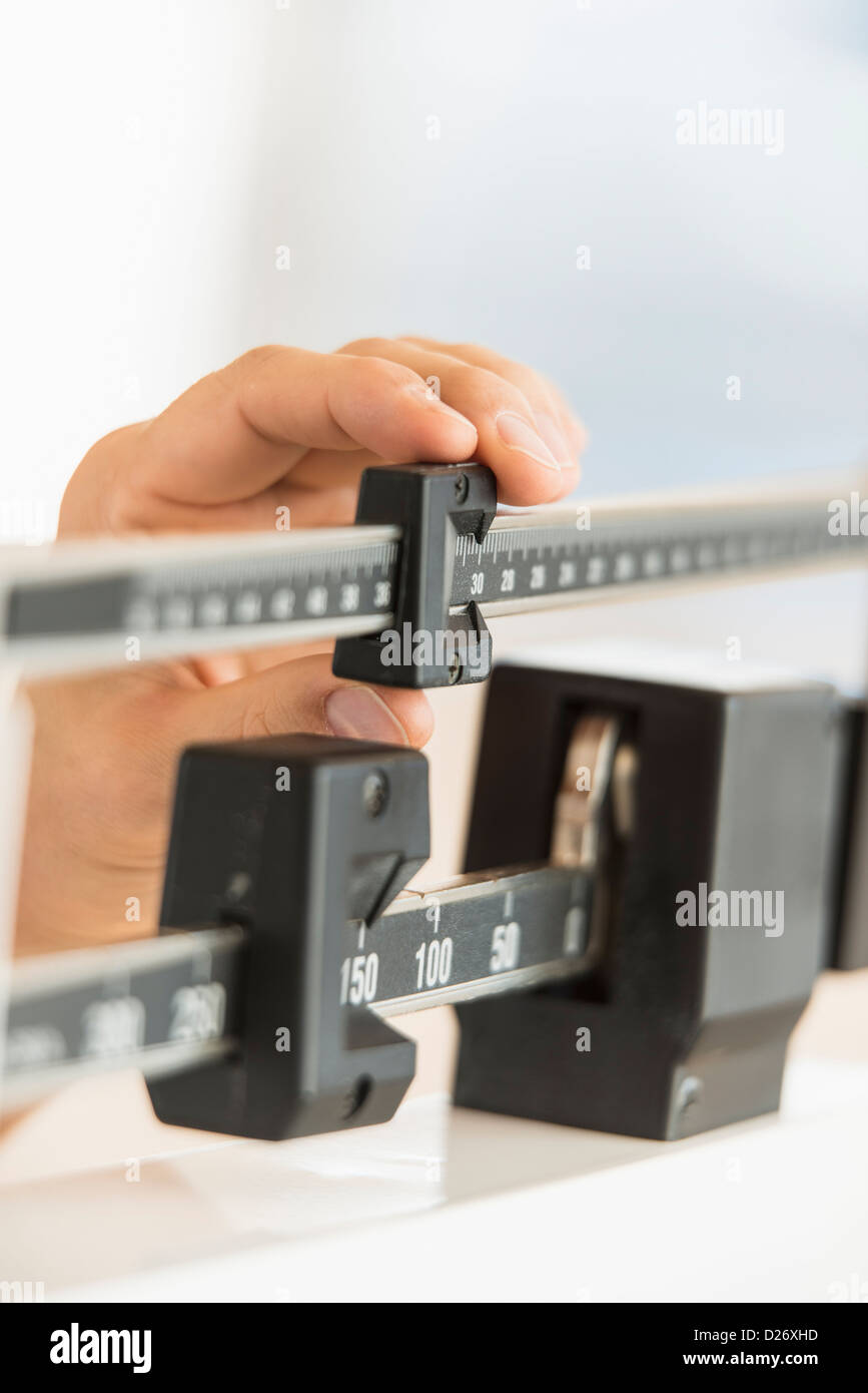 Hand adjusting weight scales Stock Photo - Alamy