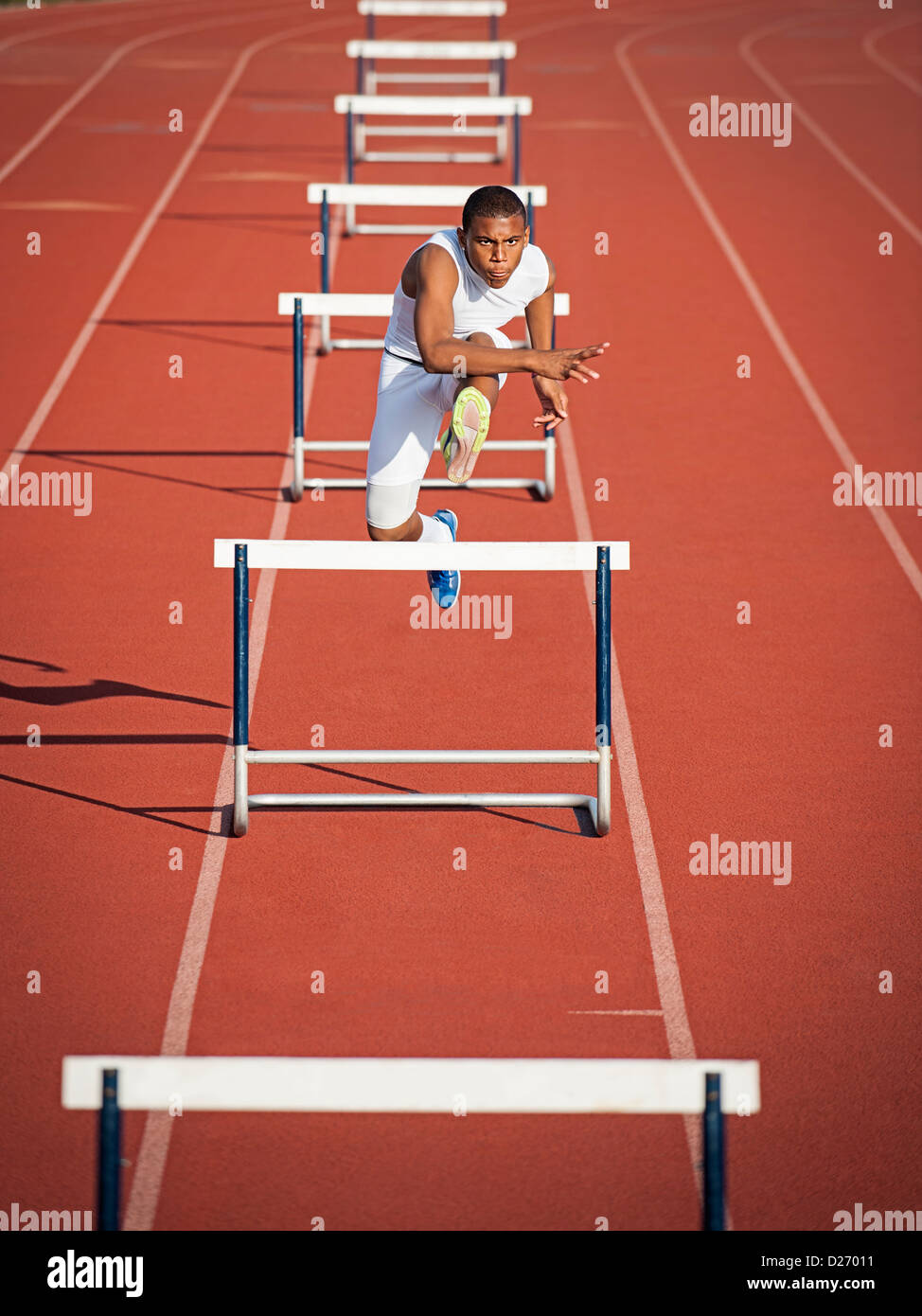 USA, California, Fontana, Boy (12-13) hurdling on running track Stock ...