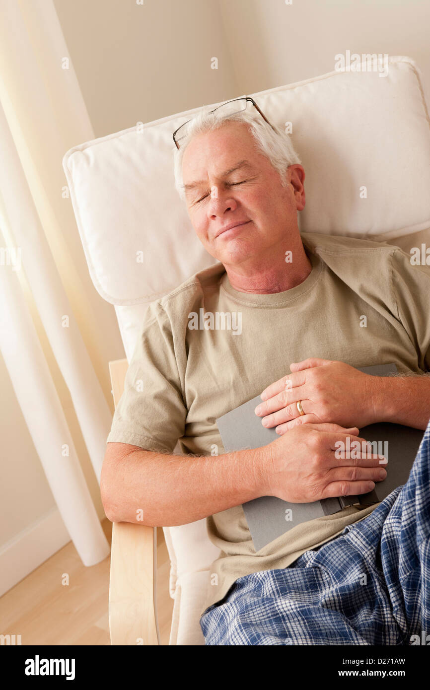 Senior man taking nap and holding book Stock Photo - Alamy