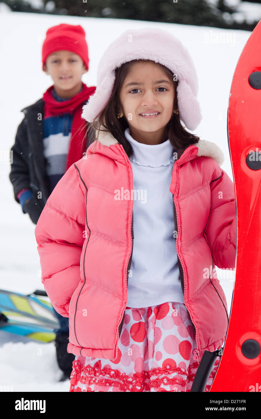 A brother and a sister get ready to go toboganning in the snow Stock ...