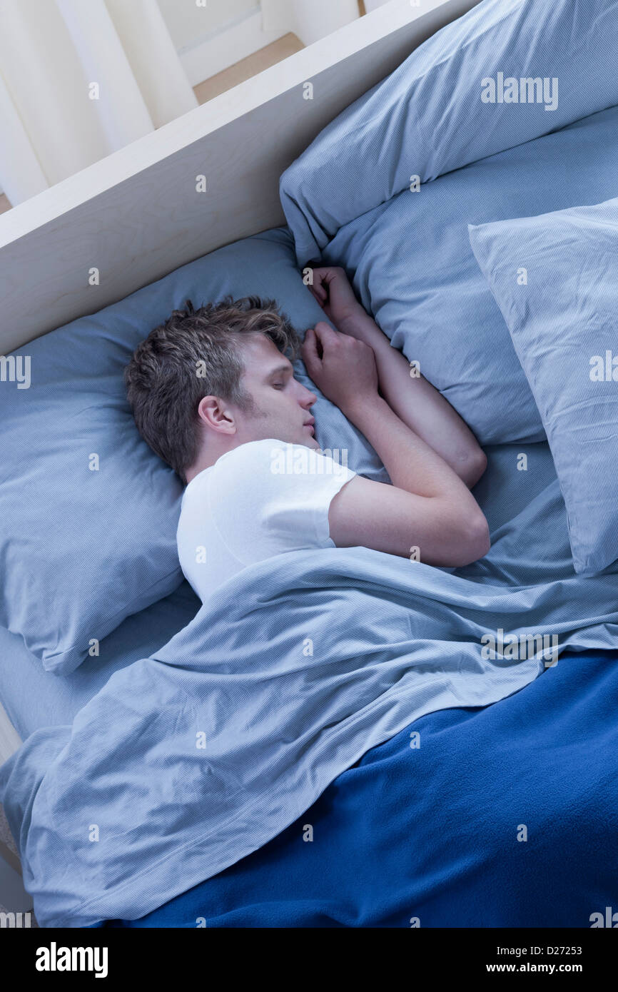 Elevated view of man sleeping on bed Stock Photo - Alamy