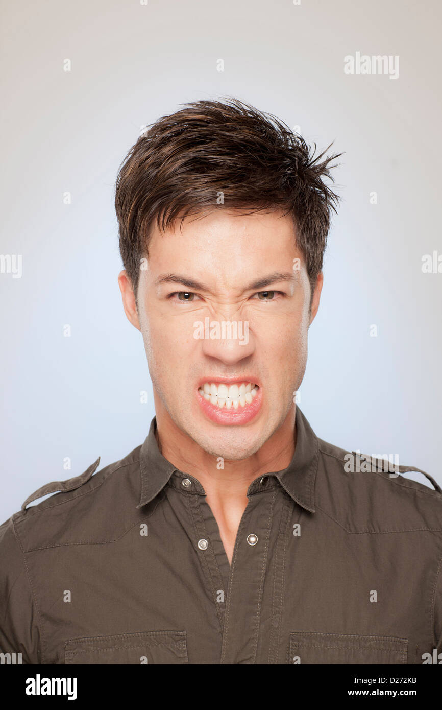 Portrait of man clenching teeth Stock Photo - Alamy