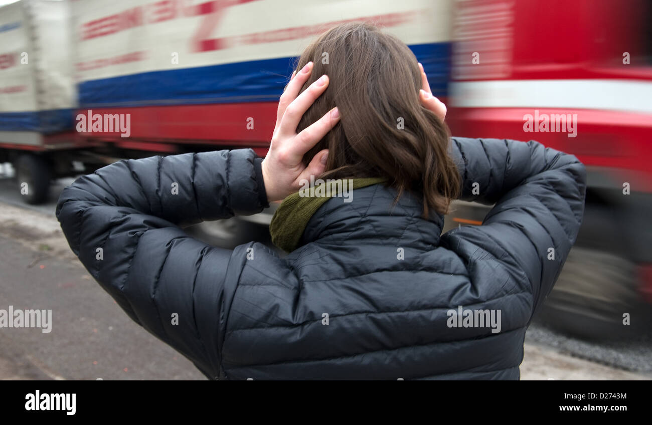 The illustration shows a woman holds her ears as a lorry drives by in ...