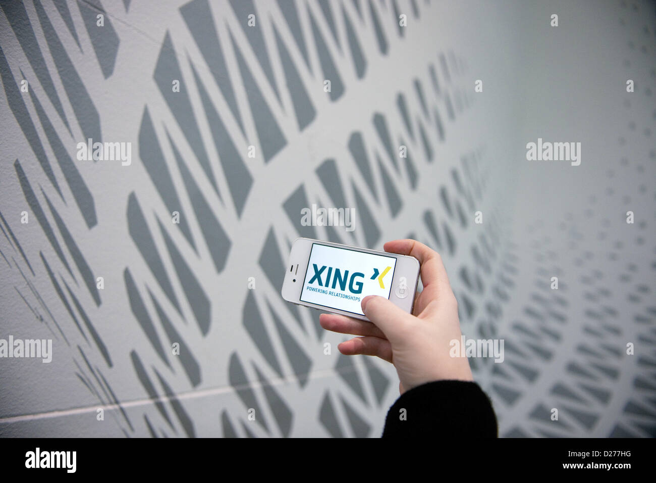 A woman shows the network XING on the display of her mobile phone Stock ...