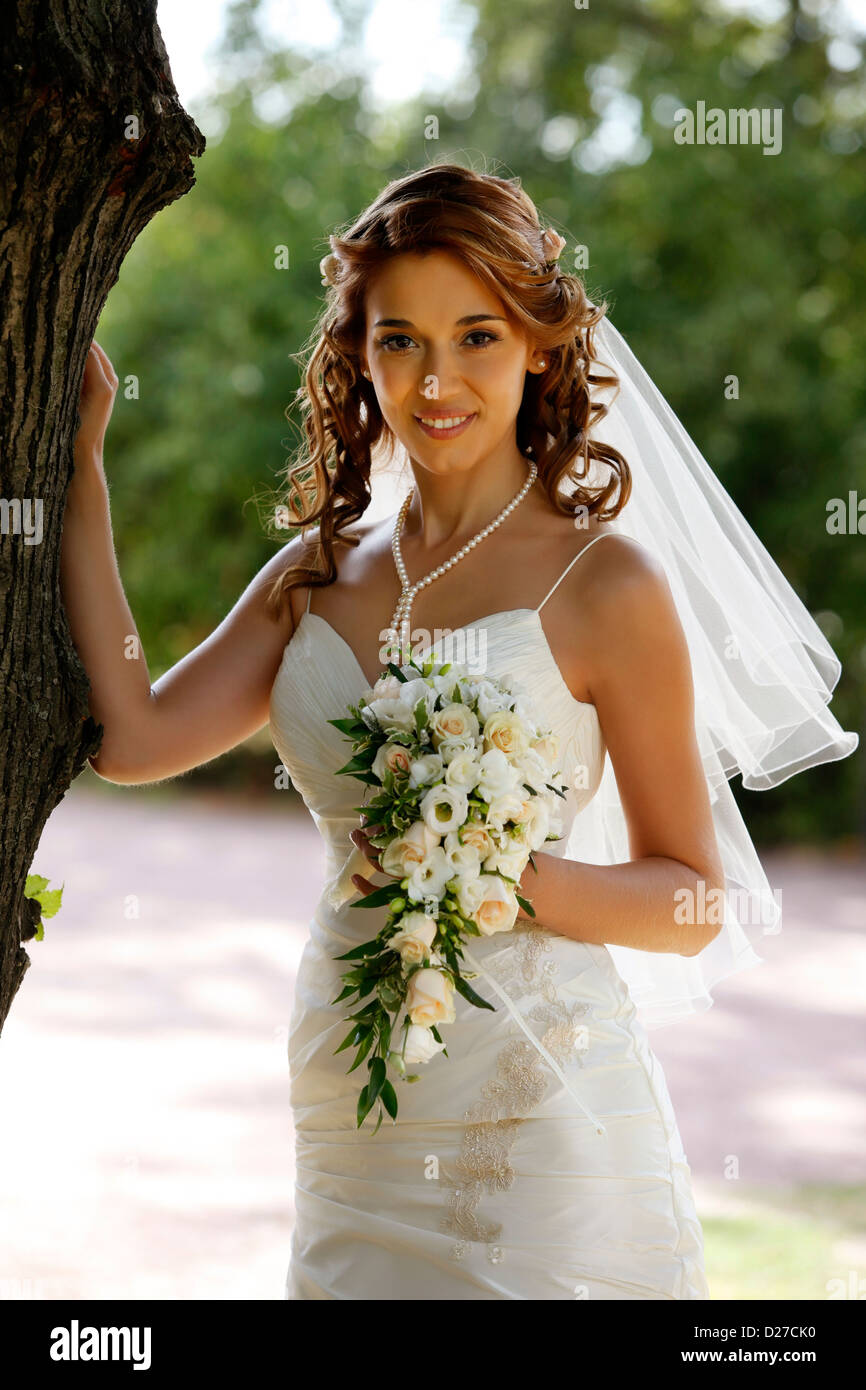 The beautiful bride with bouquet in park Stock Photo - Alamy