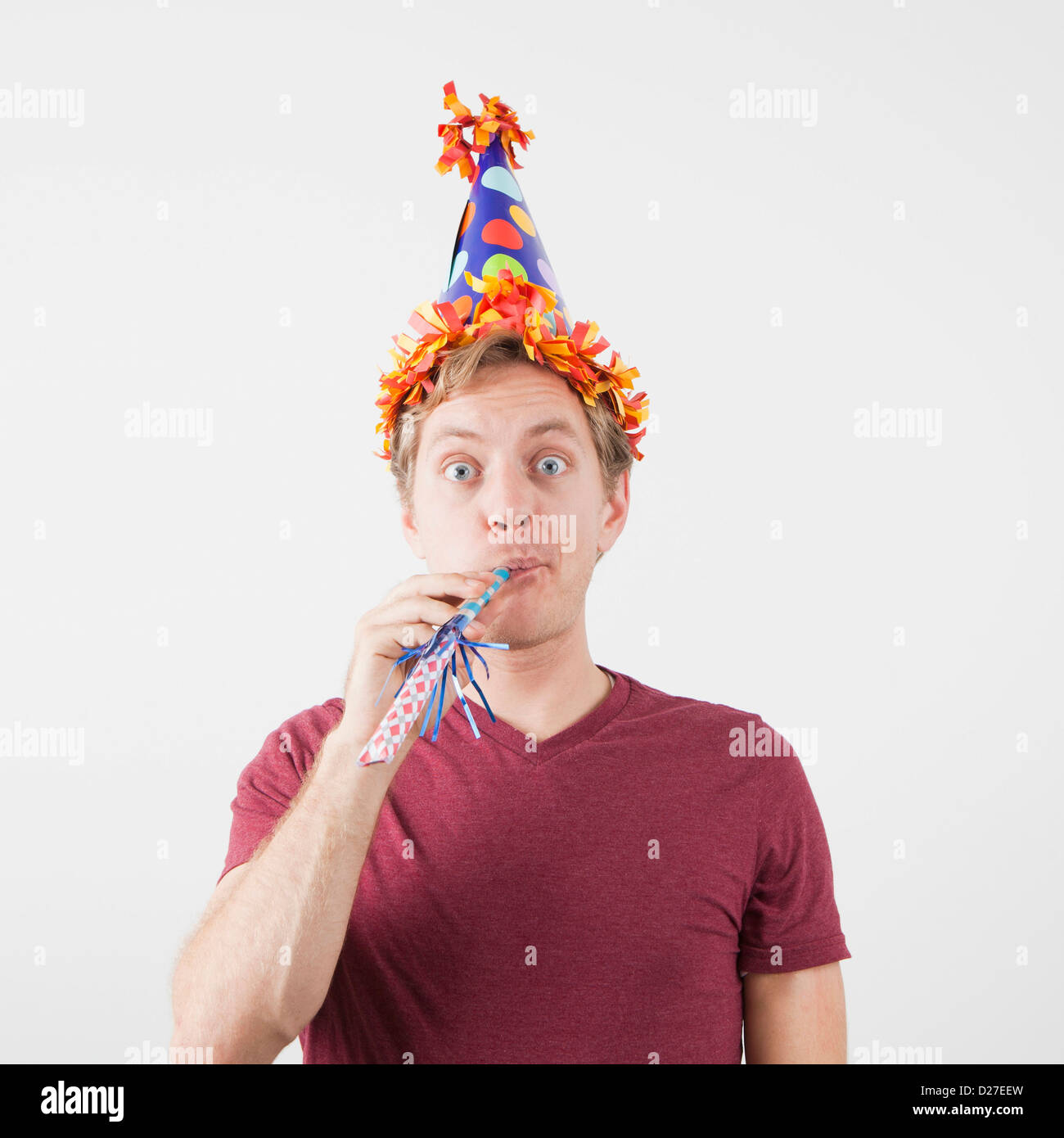 Man with party hat and party horn blower Stock Photo - Alamy