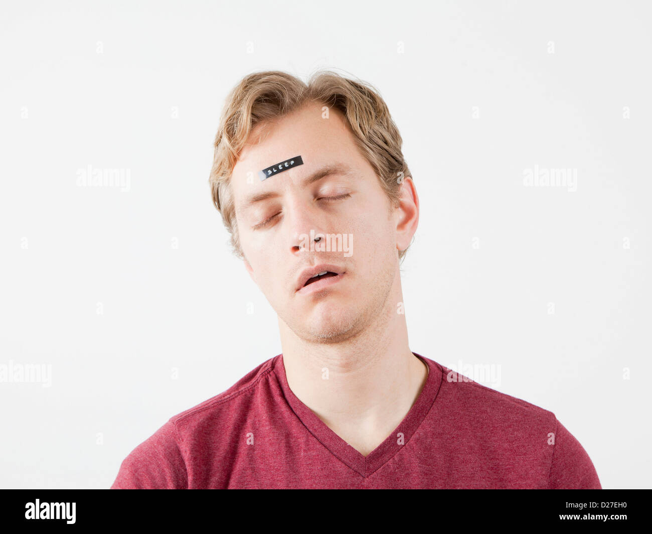 Sleeping man with sticker on his forehead Stock Photo - Alamy