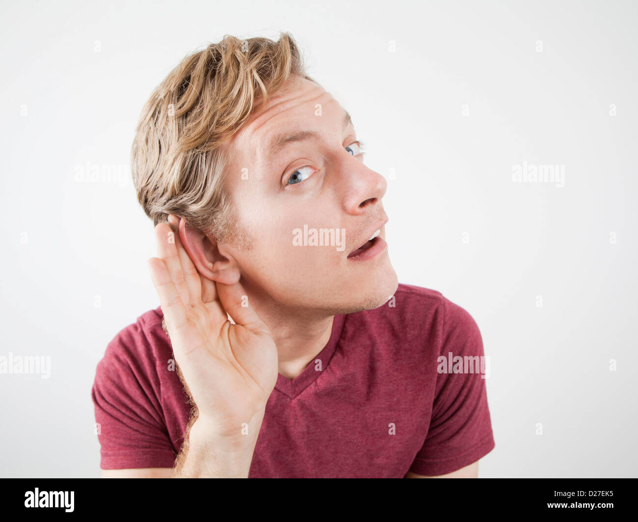 Man cupping his ear with his hand Stock Photo - Alamy