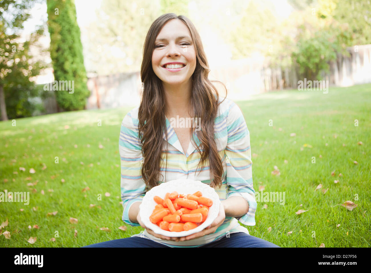 USA, Utah, Salt Lake City, portrait of mid adult woman eating carrots ...