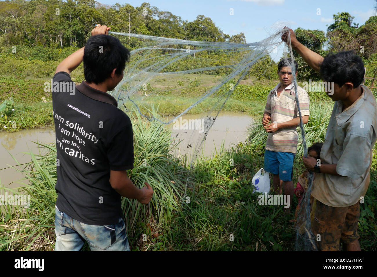 Cambodia - men using fishing net in pond Stock Photo - Alamy