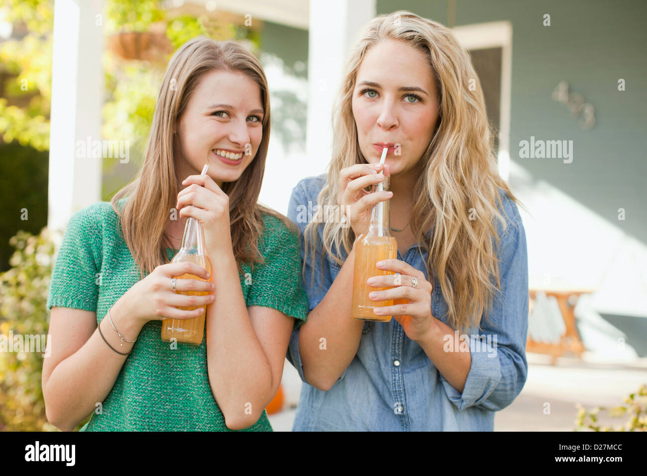 USA, Utah, Provo, Portrait of two friends drinking soda through straw ...