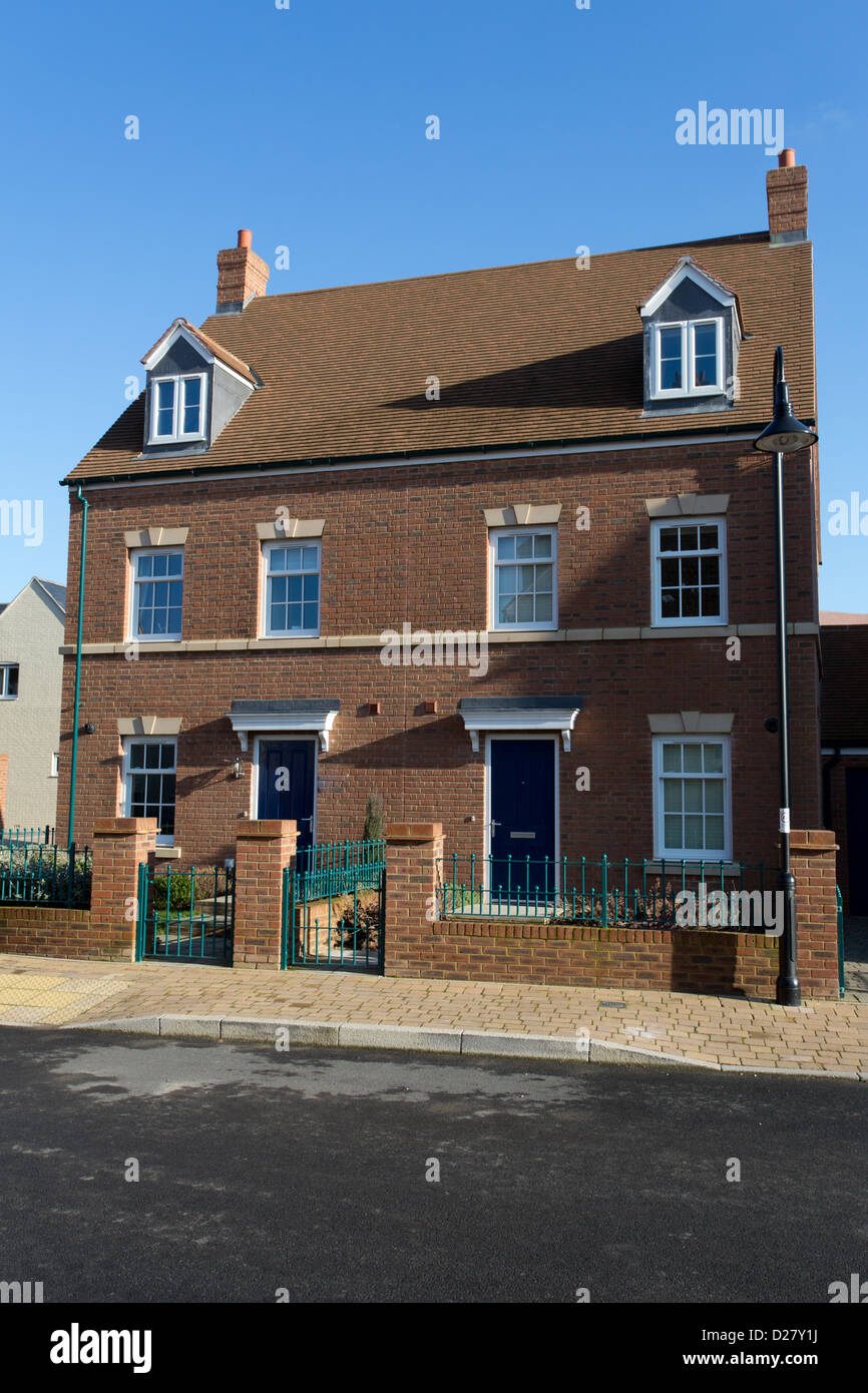 A pair of new semi-detached three storey homes with dormer windows ...