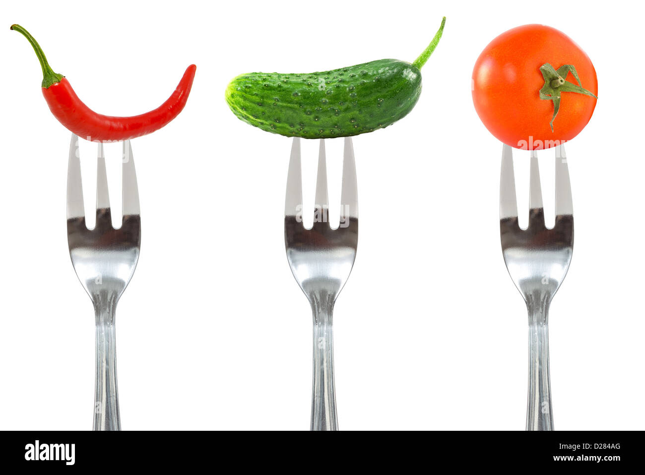 Diet concept. Vegetables on the forks, isolated over a white background ...