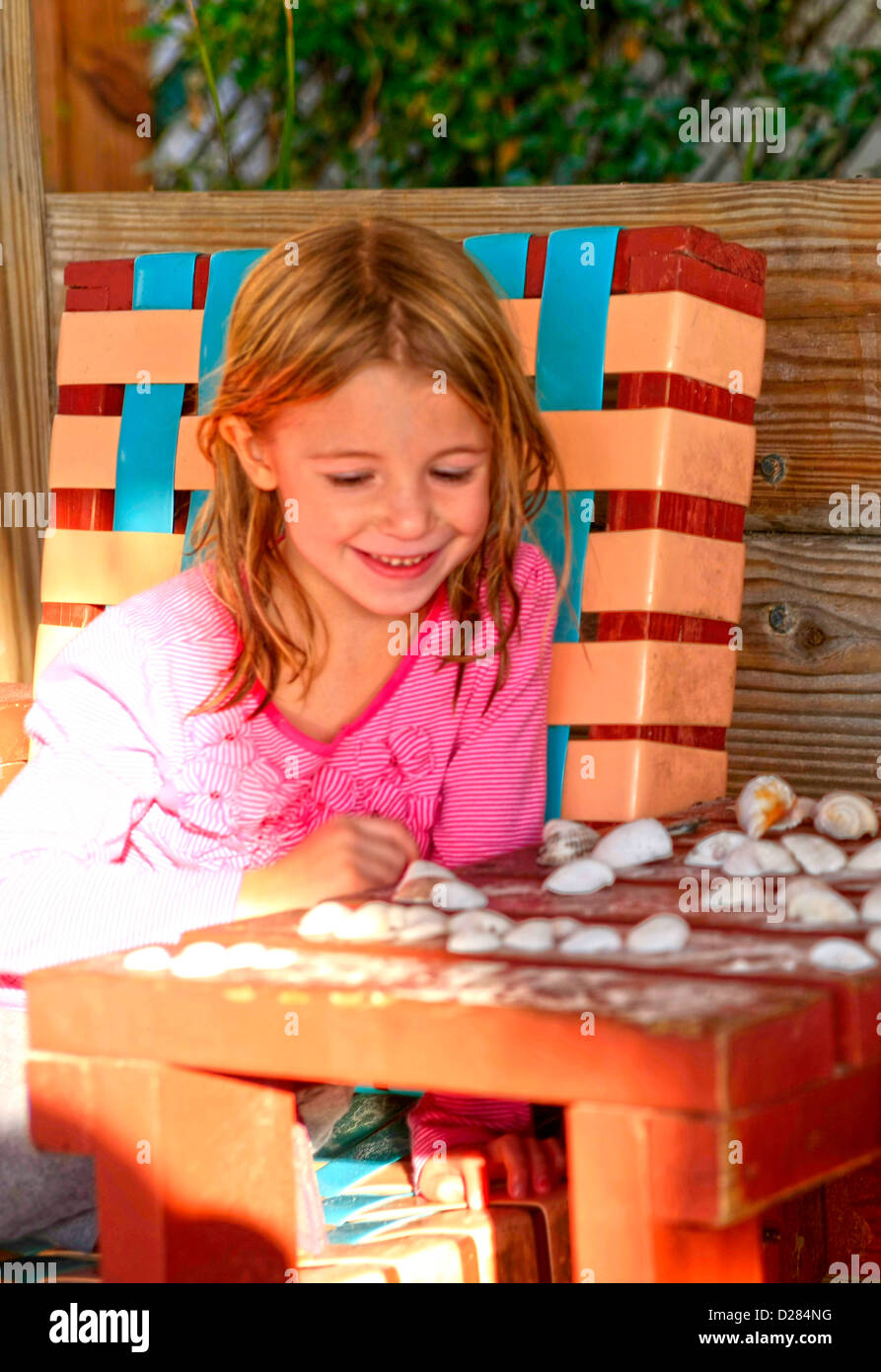 Young girl viewing her sea shell collection at Siesta Key beach in ...
