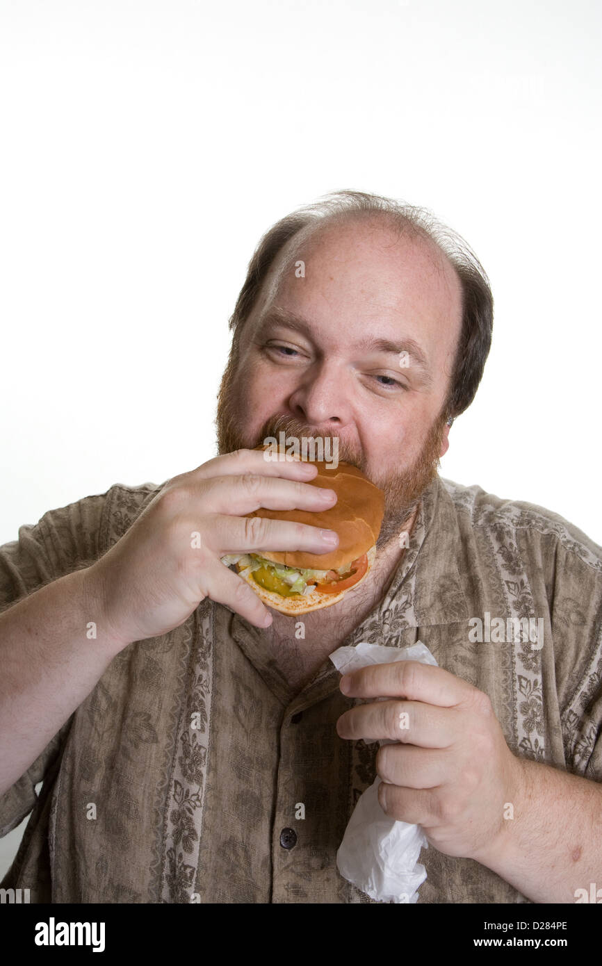 Overweight man in mid forties eating fast food Stock Photo - Alamy