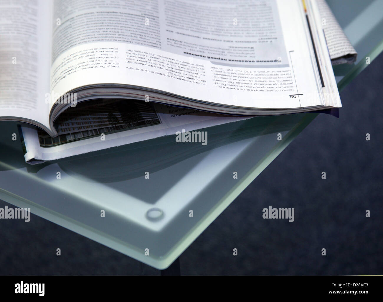 Open magazines on a glass table Stock Photo - Alamy