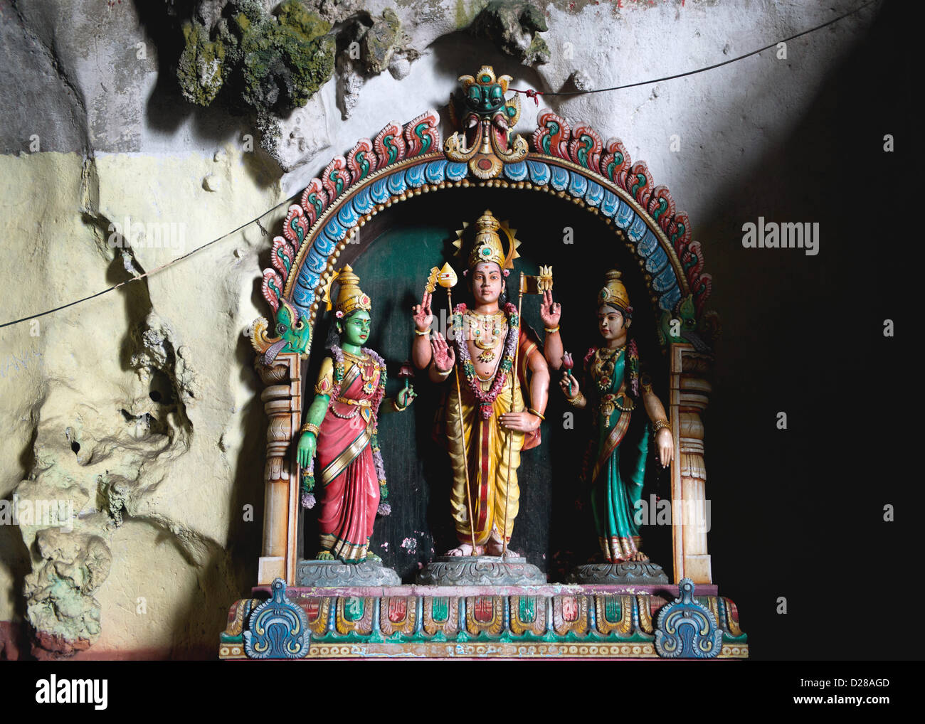 A set of Hindu gods stand in the niche of a cave on the Hindu temple ...